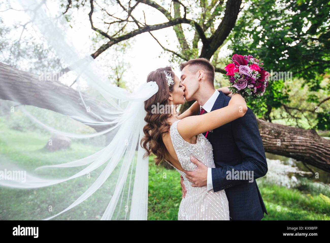 Married couple kissing in park Stock Photo - Alamy