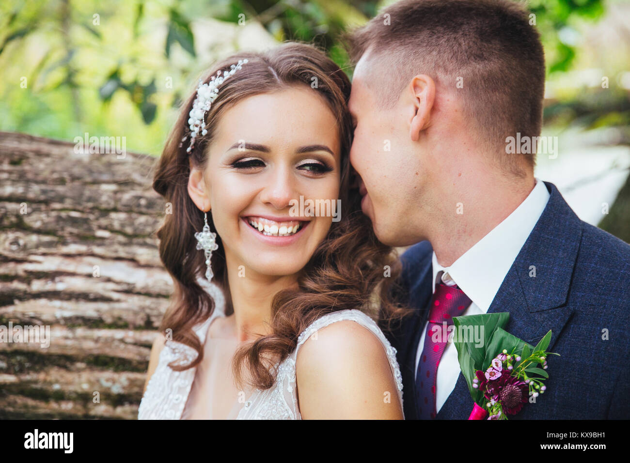 Beautiful wedding couple in park. Bride and groom kissing and hugging each other .Happy wedding ...