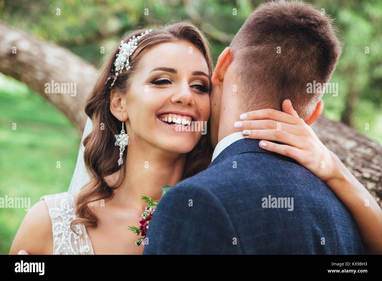 Beautiful wedding couple in park. They kiss and hug each other Stock Photo - Alamy