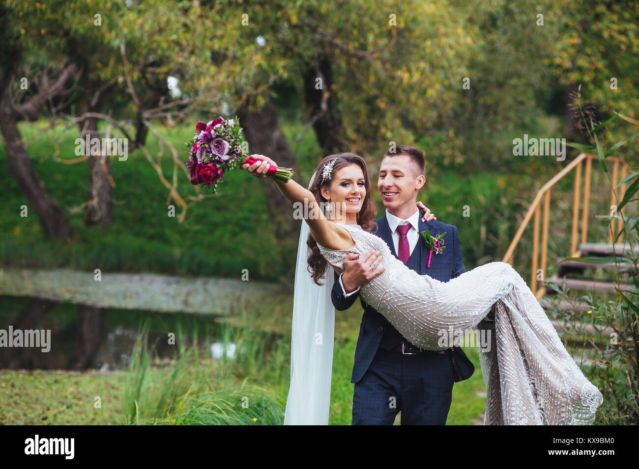 Groom carrying his beautiful bride Stock Photo - Alamy