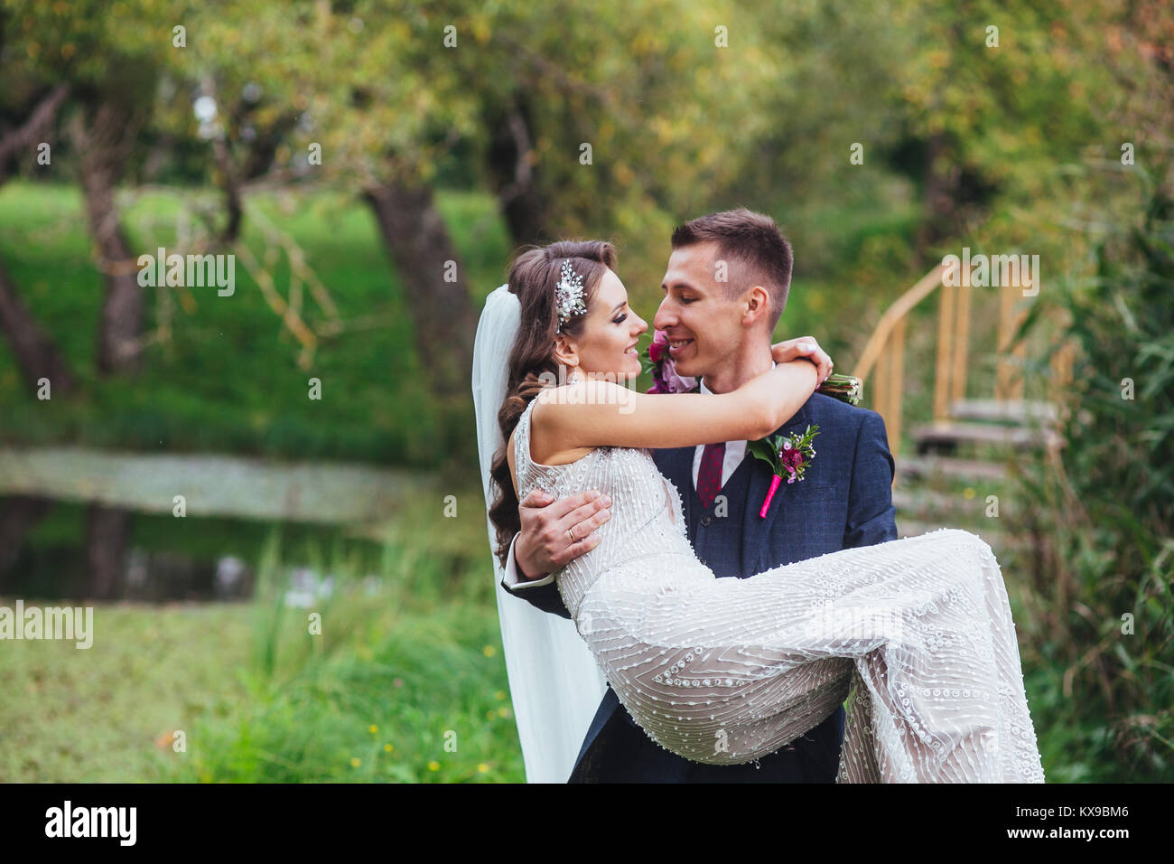 Groom carrying his beautiful bride Stock Photo - Alamy