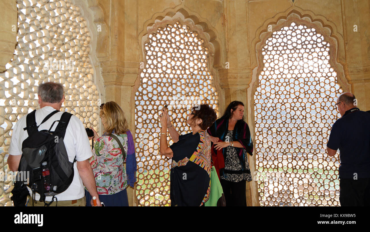 Tourist looking Through Window and enjoying Amber fort architecture ...