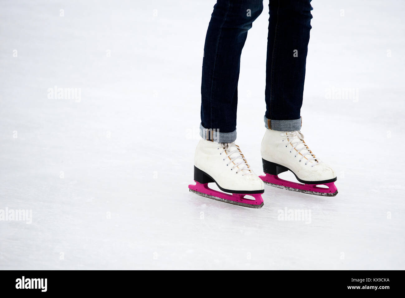 Young woman ice skating outdoors on a ice rink on a freezing winter day ...