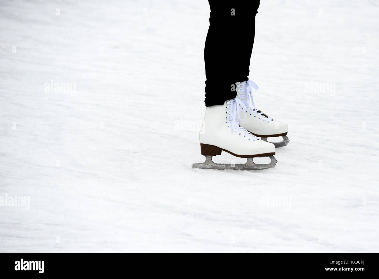 Young woman ice skating outdoors on a ice rink on a freezing winter day ...