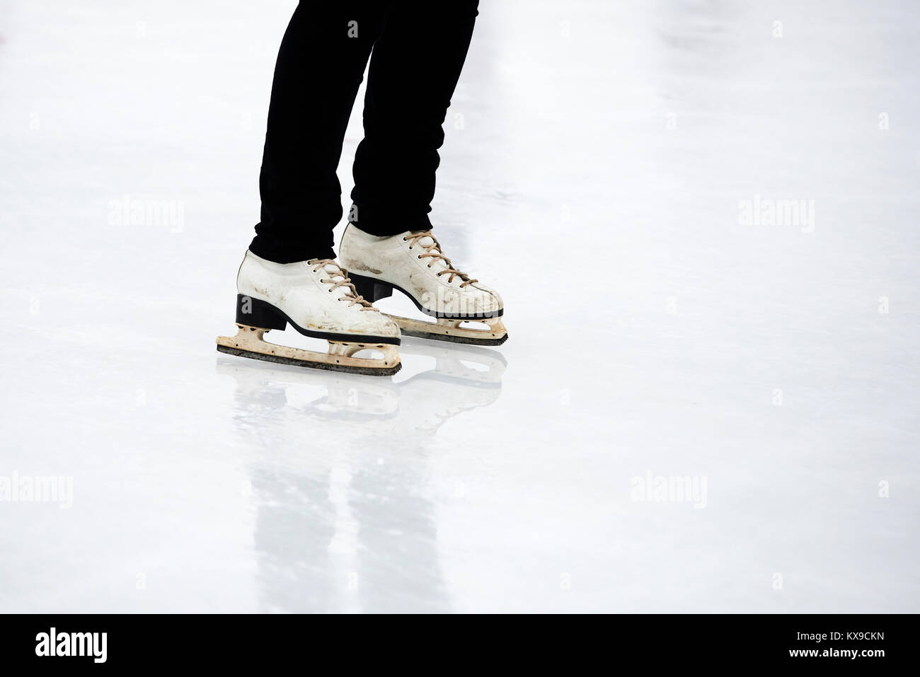 Young woman ice skating outdoors on a ice rink on a freezing winter day ...