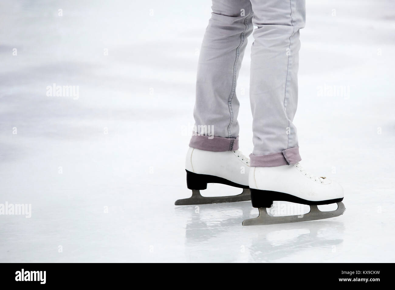 Young woman ice skating outdoors on a ice rink on a freezing winter day ...