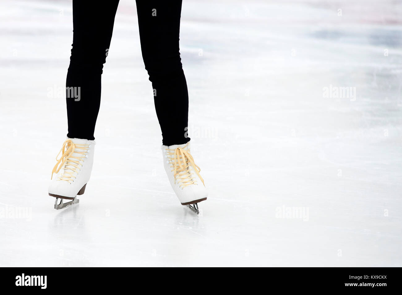 Young woman ice skating outdoors on a ice rink on a freezing winter day ...