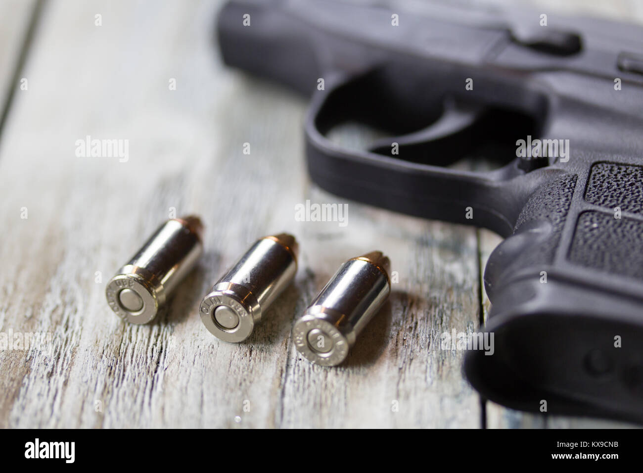 A black pistol hand gun with bullets on a wooden background Stock Photo ...