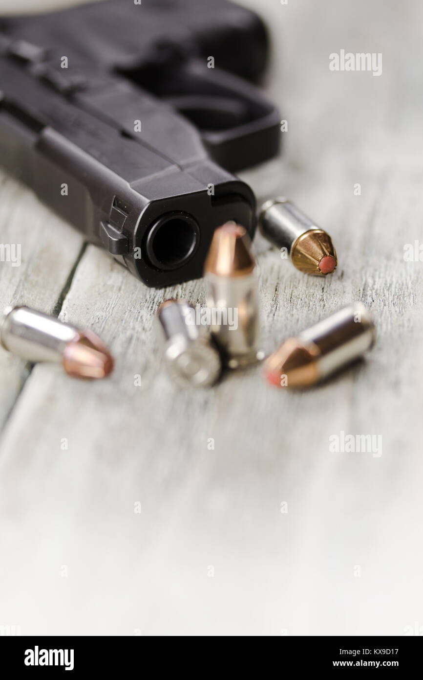 A black pistol hand gun with bullets on a wooden background Stock Photo ...