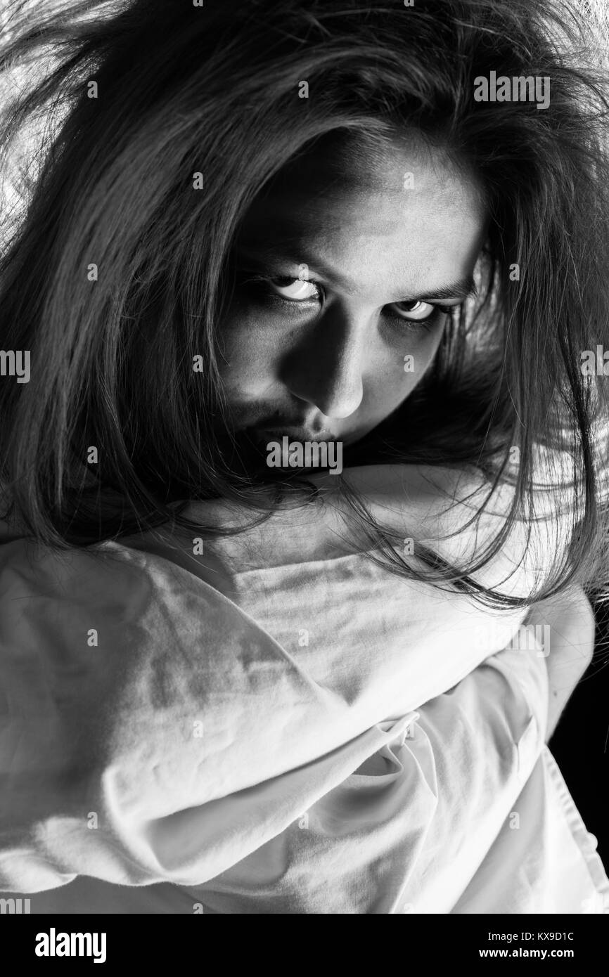 screaming crazy woman with fluffy hair in straitjacket looking at ...