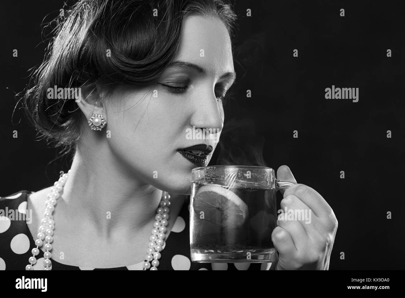 beautiful pinup woman with cup of tea on black background, monochrome ...
