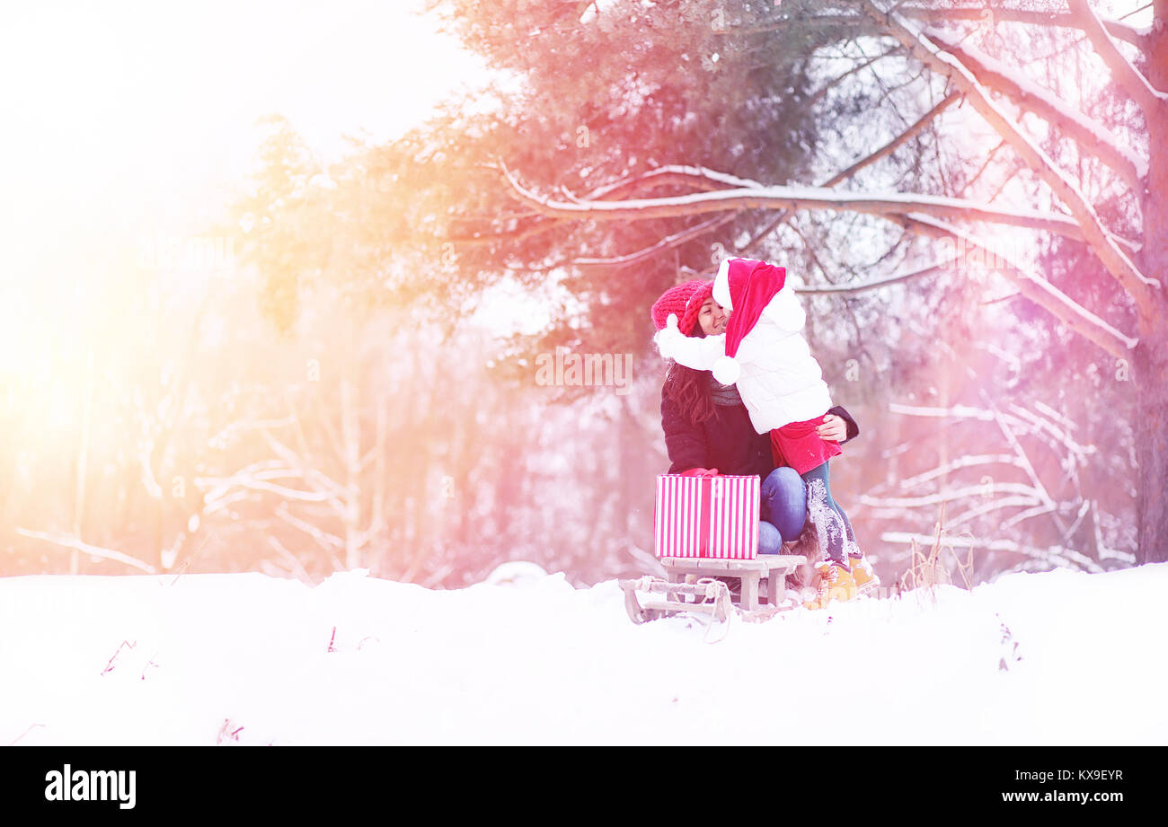 A winter fairy tale, a young mother and her daughter ride a sled Stock ...