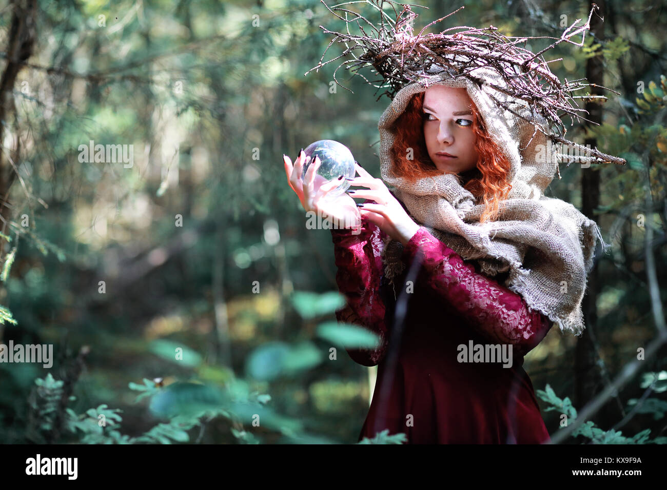 The red-haired witch holds a ritual with a crystal ball Stock Photo - Alamy
