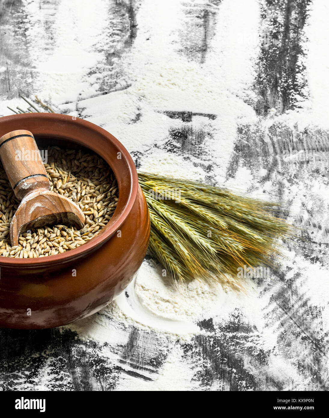 Wheat grains with a scoop in a bowl. On the stone table Stock Photo - Alamy