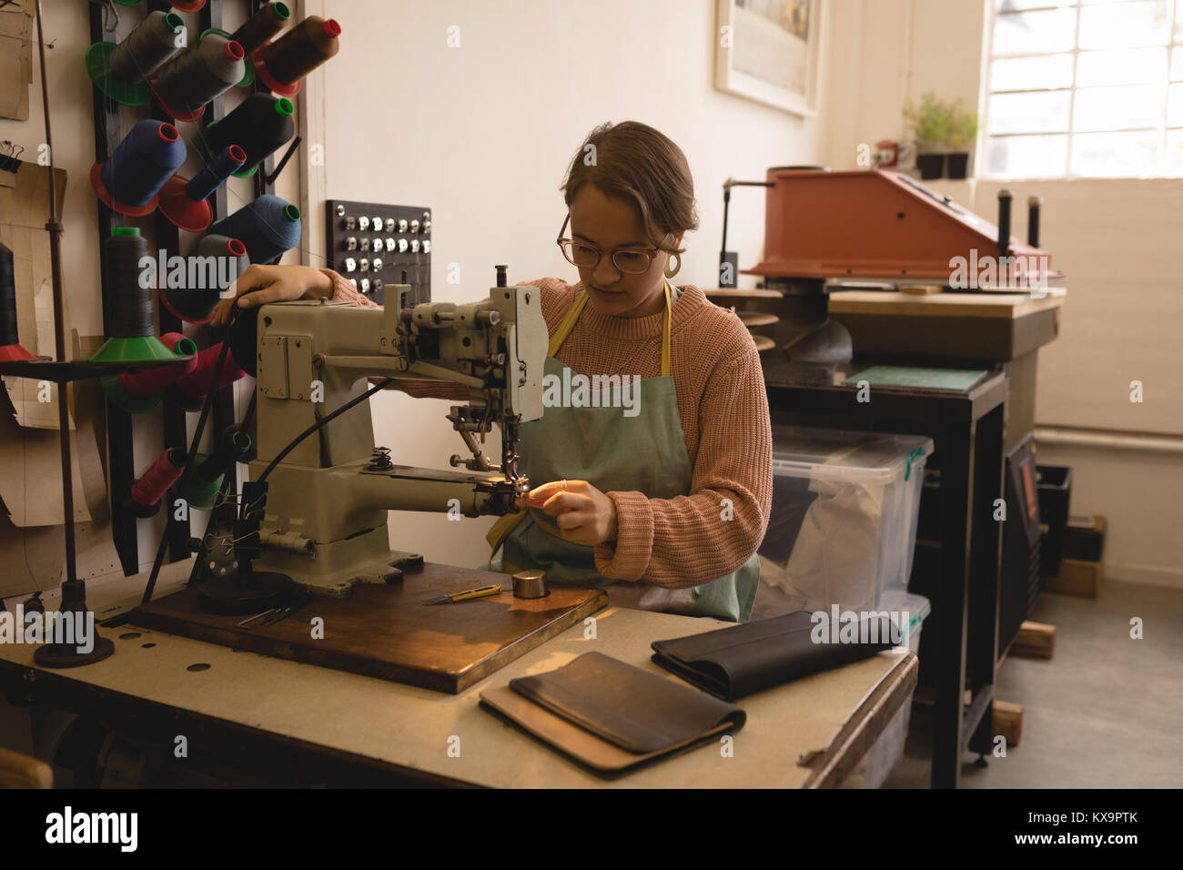 Worker putting thread into sewing machine Stock Photo - Alamy