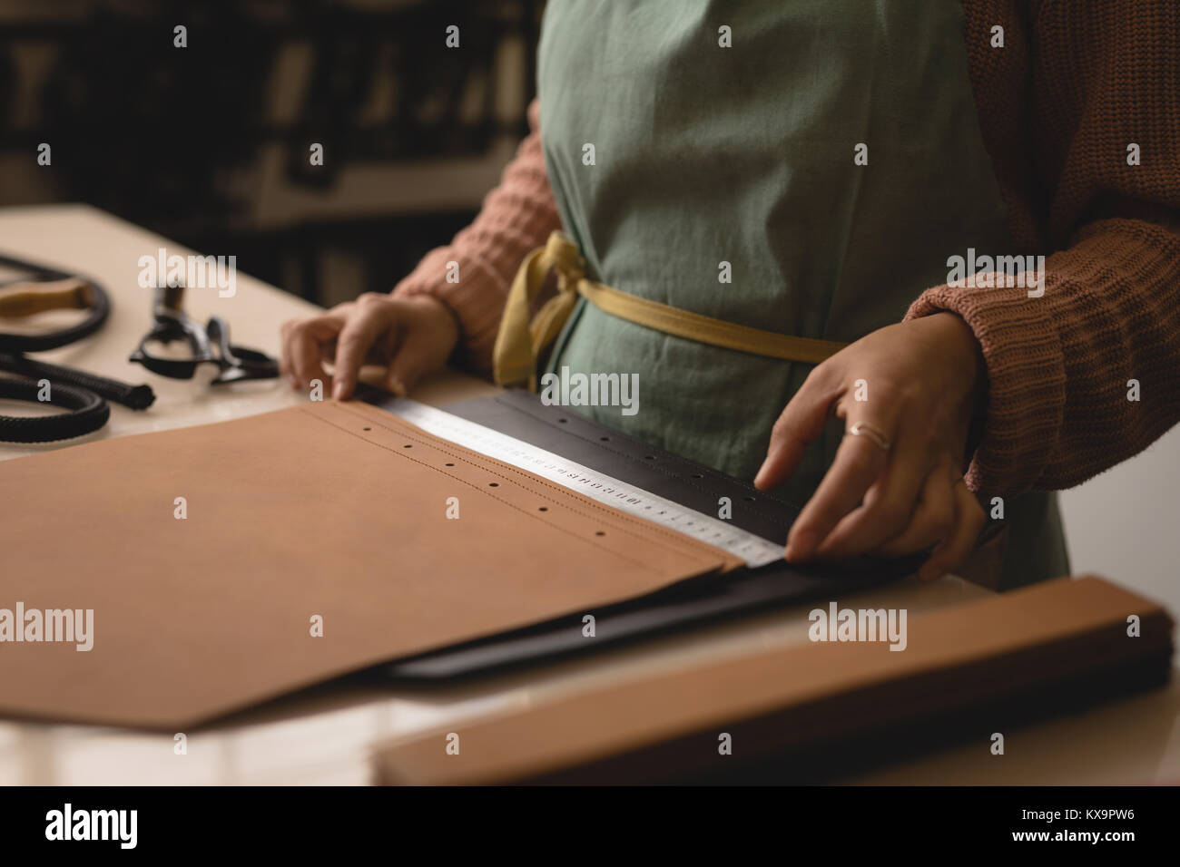 Worker measuring leather with ruler in workshop Stock Photo - Alamy