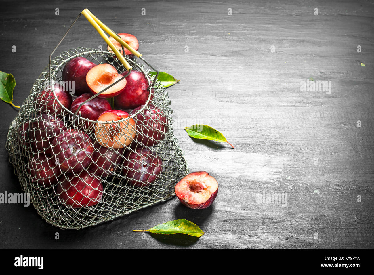 Fresh plums with a mesh bag. On the black chalkboard Stock Photo - Alamy