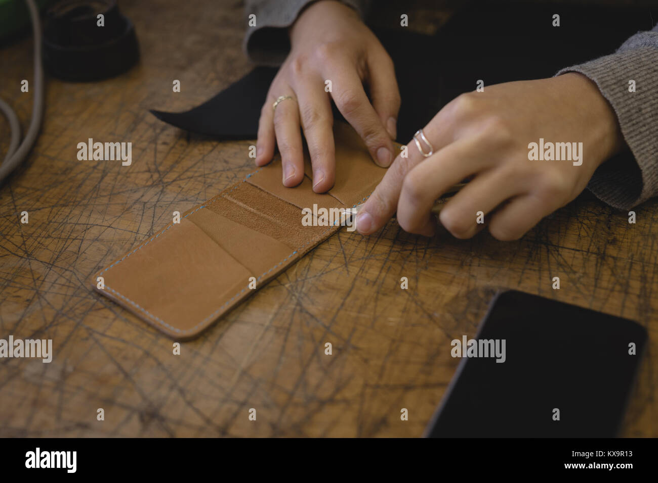 Worker checking leather sheet in workshop Stock Photo - Alamy