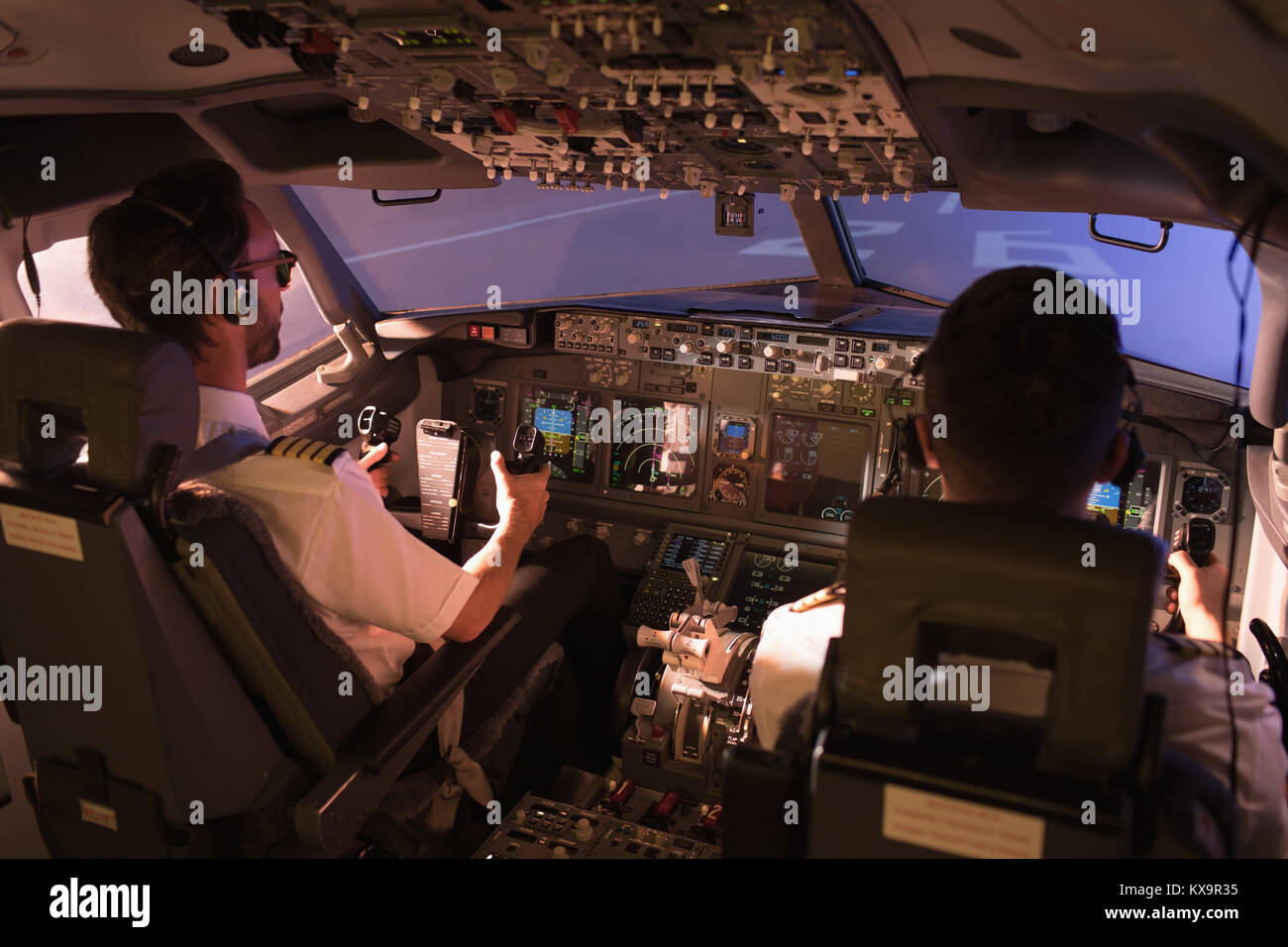 Pilot and copilot flying an airplane Stock Photo - Alamy