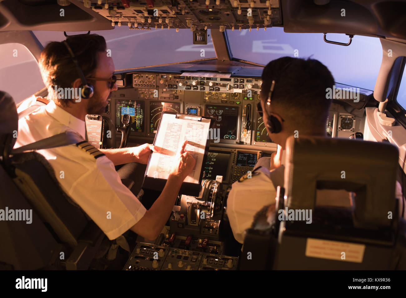 Pilot and copilot discussing over clipboard Stock Photo - Alamy