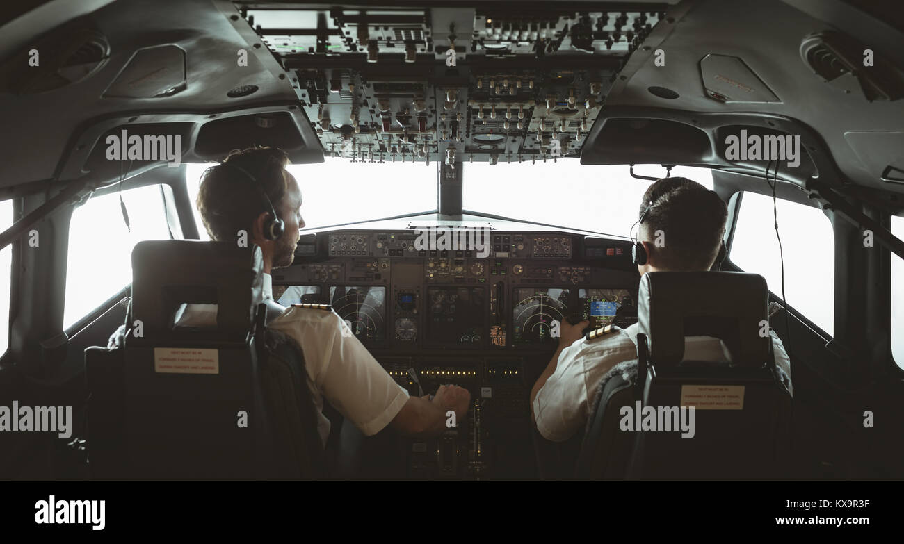 Pilot and copilot flying an airplane Stock Photo - Alamy