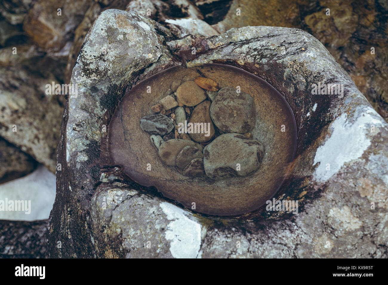 Rock cavity filled with water and rock pieces Stock Photo - Alamy