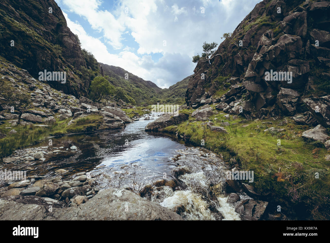 Stream flowing through mountains on countryside landscape Stock Photo ...