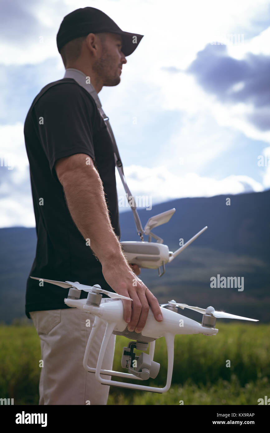 Man holding drone and a remote control before take off Stock Photo - Alamy