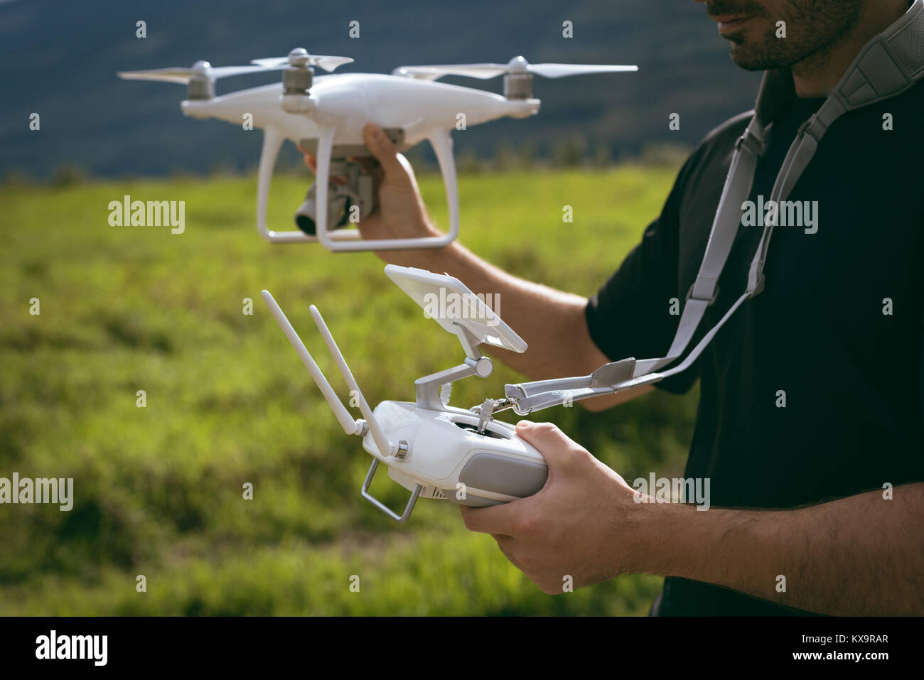 Man holding drone and remote control ready to take off Stock Photo - Alamy