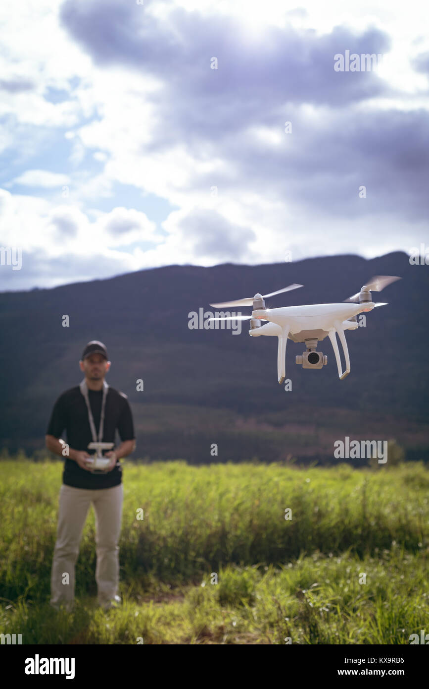 Man operating drone flying by remote control Stock Photo - Alamy