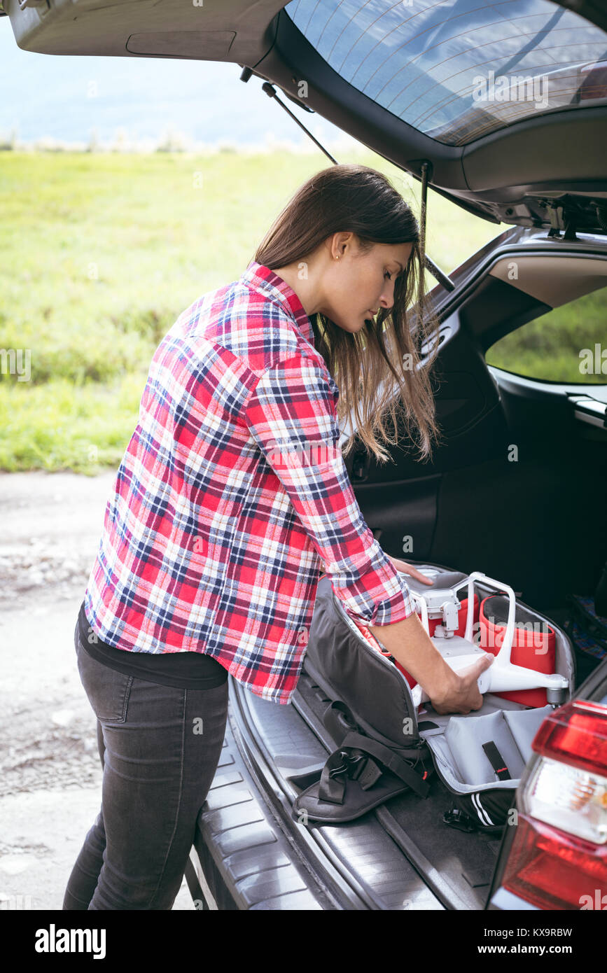 Woman taking out drone from car boot space Stock Photo - Alamy