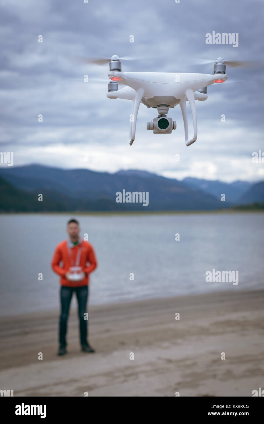 Man operating drone flying by remote control Stock Photo - Alamy