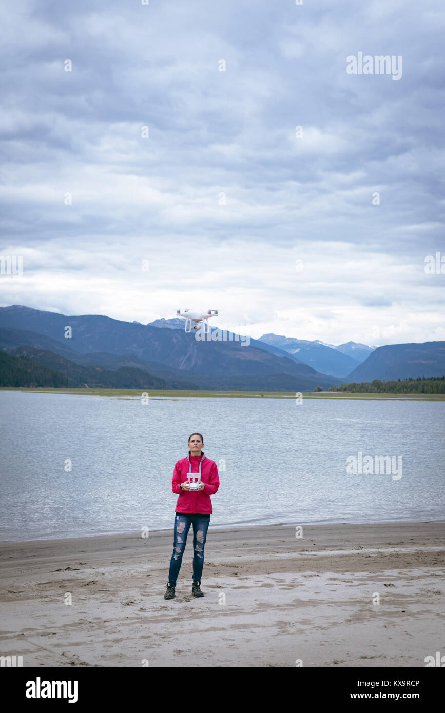 Woman operating drone flying by remote control Stock Photo - Alamy