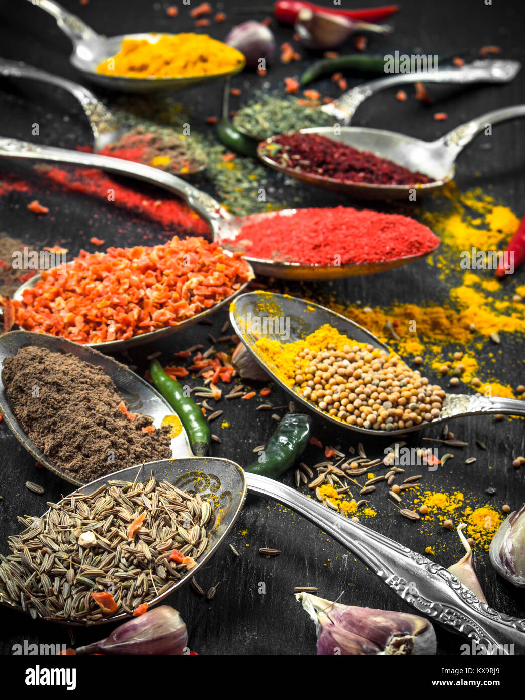Ground spices and herbs in spoons. On the black chalkboard Stock Photo ...