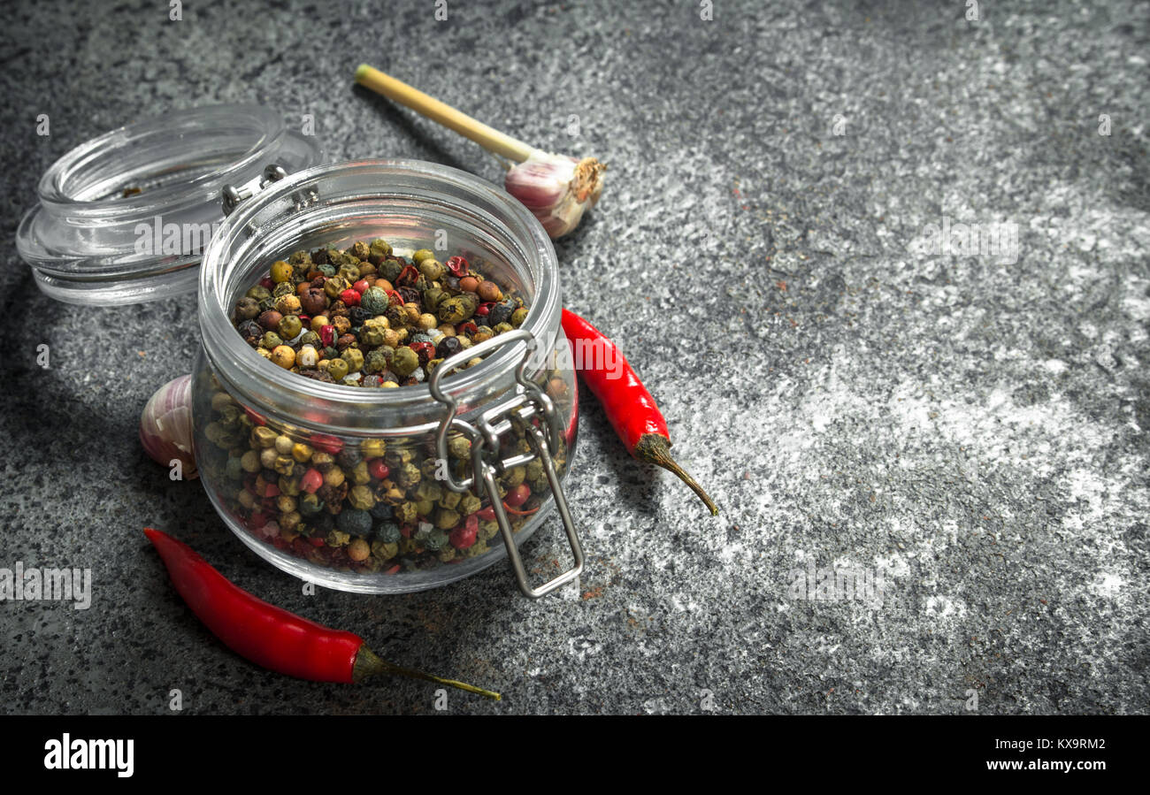 Pepper in a glass jar with garlic. On a rustic background Stock Photo ...