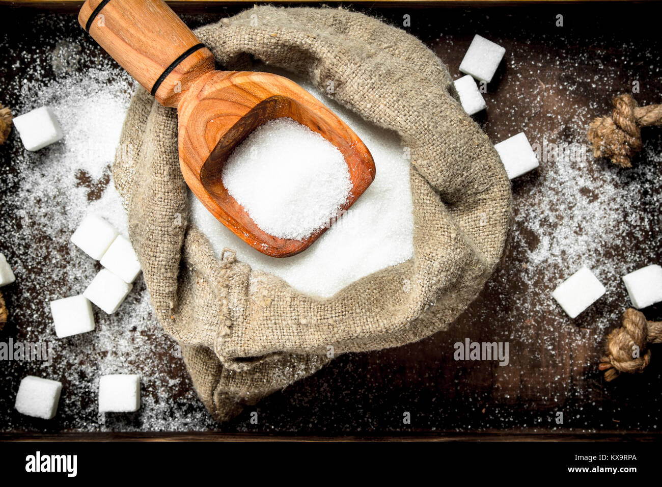 Sugar in an old sack with a scoop. On a rustic background Stock Photo ...