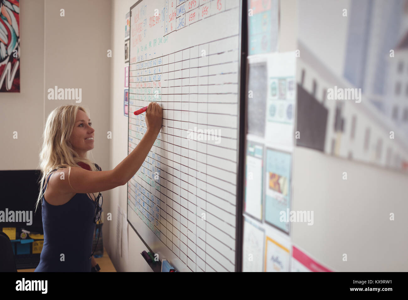 Female executive writing on whiteboard in office Stock Photo - Alamy