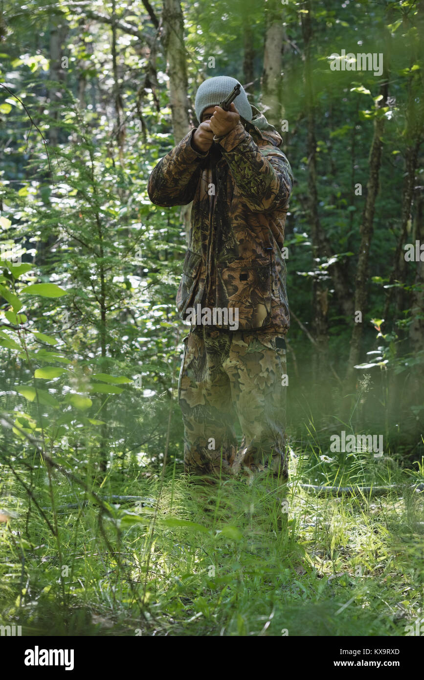 Hunter shooting with rifle in forest Stock Photo - Alamy