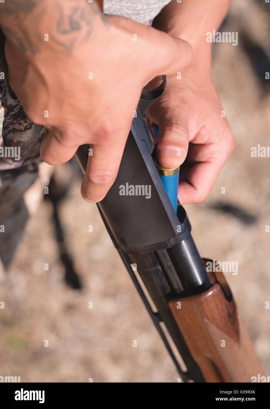 Hunter loading bullet into rifle Stock Photo - Alamy