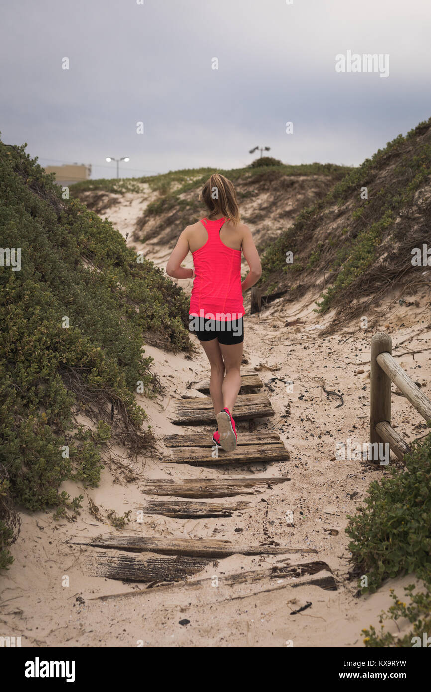Woman jogging on the boardwalk at beach Stock Photo - Alamy