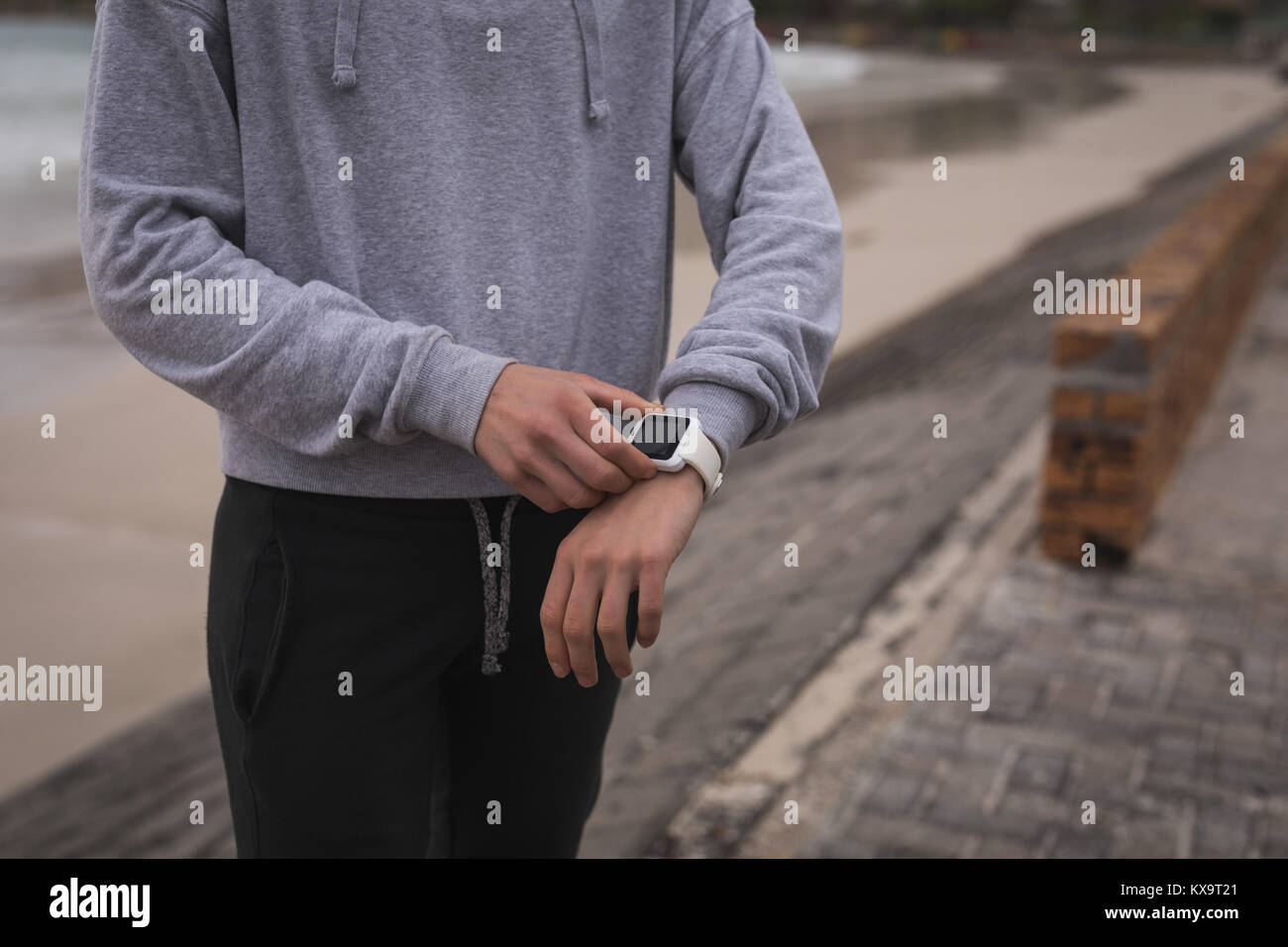 Athlete checking and adjusting watch Stock Photo - Alamy