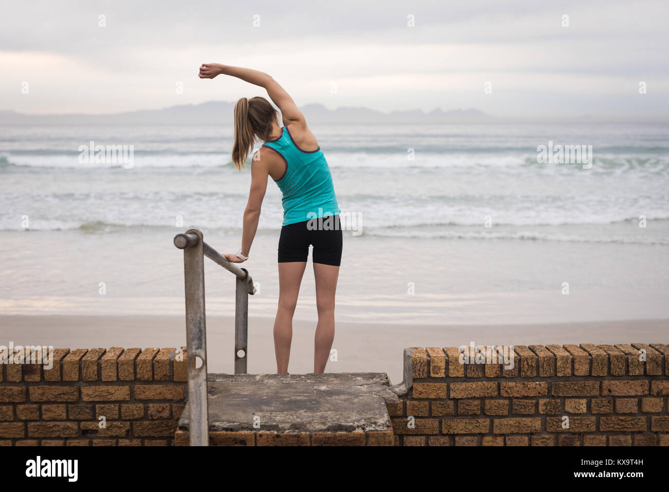 Woman performing stretching exercise near beach Stock Photo - Alamy