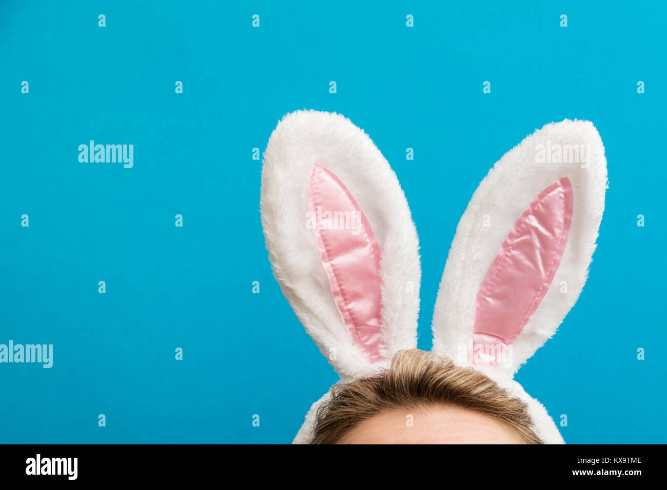 Easter bunny ears. Female wearing white bunny ears costume against a ...