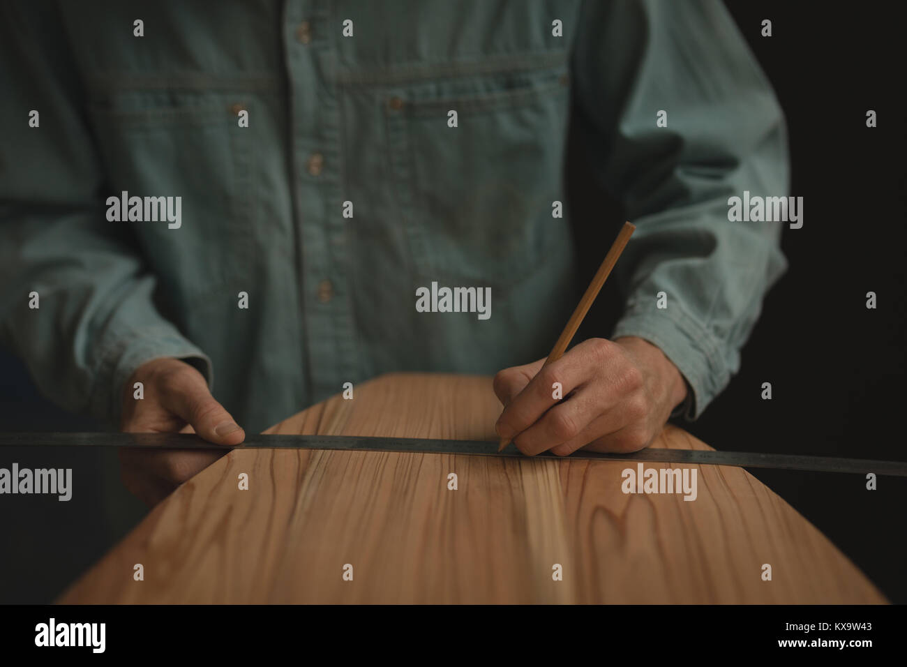 Man measuring with ruler on surfboard Stock Photo - Alamy
