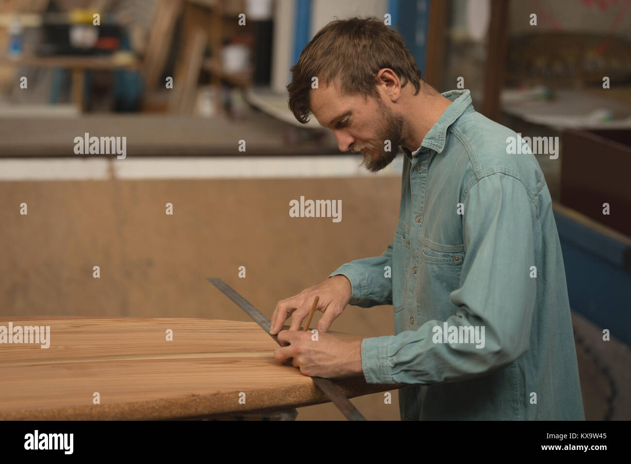 Man measuring with ruler on surfboard Stock Photo - Alamy