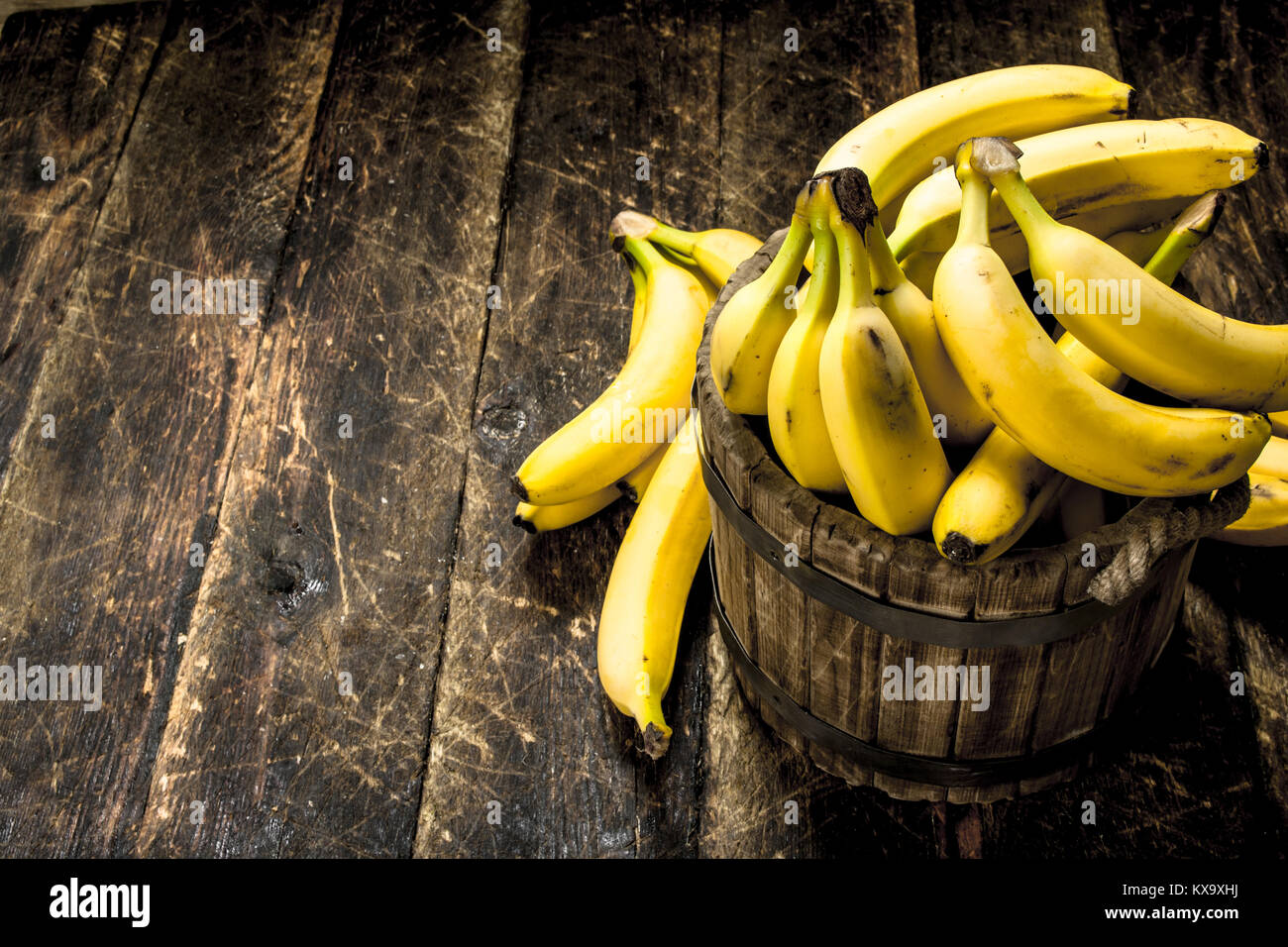 Bananas in a wooden bucket. On a wooden background Stock Photo - Alamy