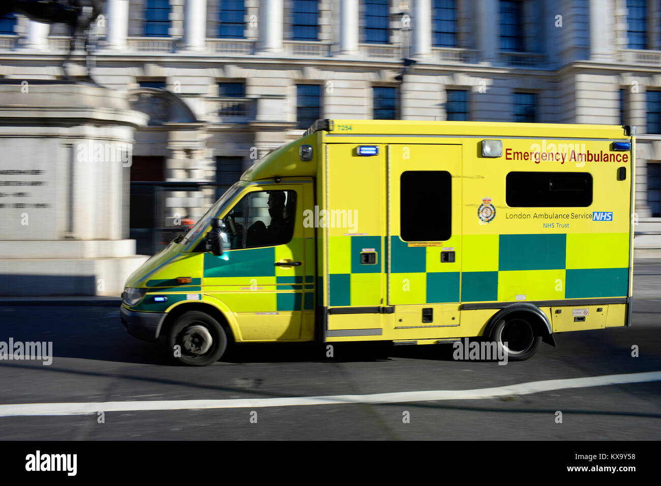Ambulance racing at speed on Whitehall, Westminster, London on a blue ...