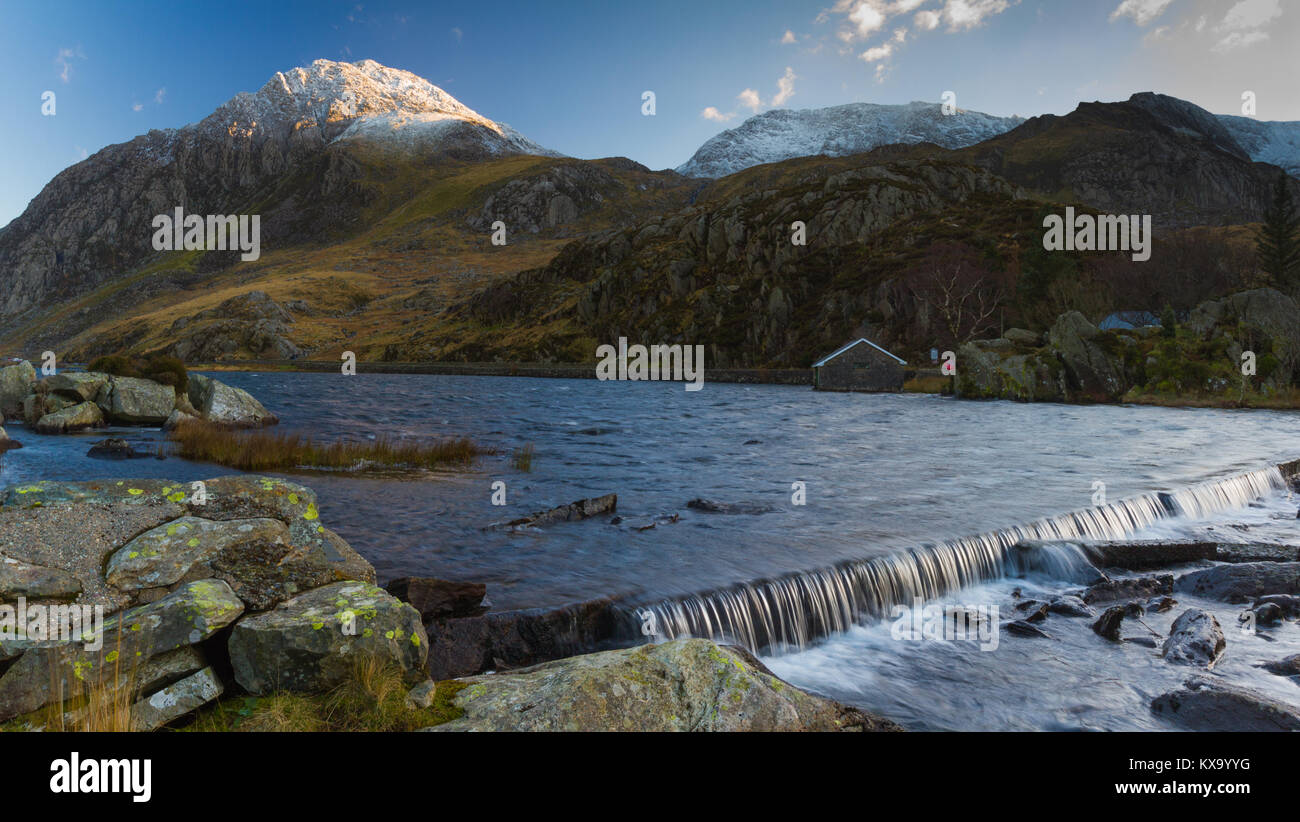 Snow capped peak of Tryfan reflected in the lake of Llyn Ogwen ...