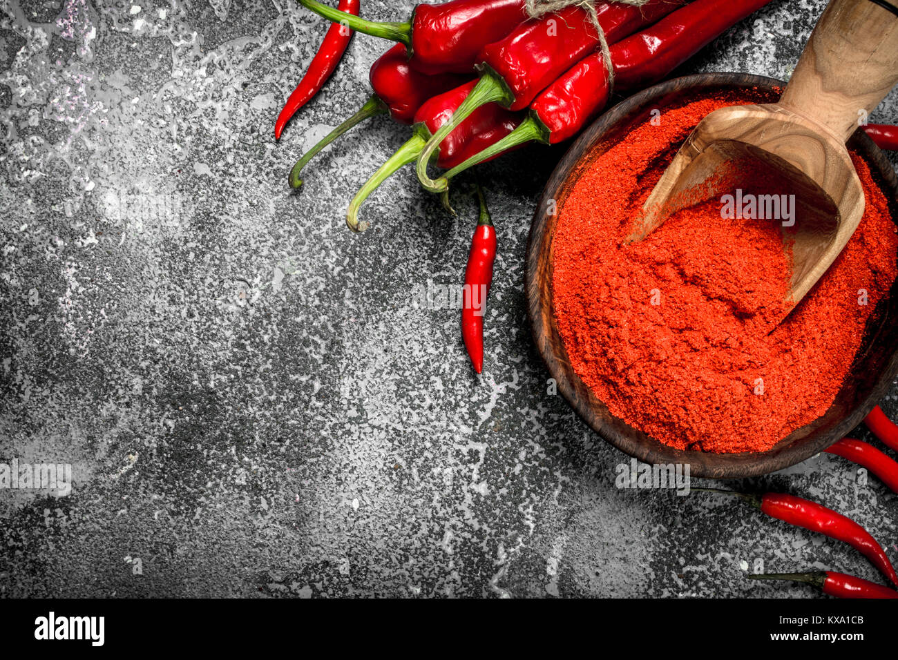 Ground chili peppers in a bowl. On a rustic background Stock Photo - Alamy