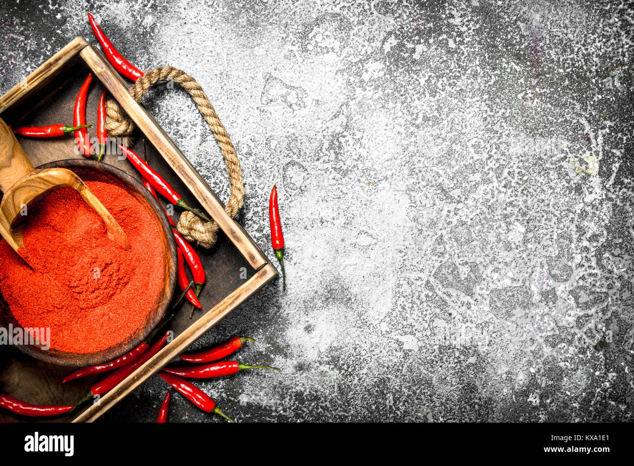 Fresh ground hot pepper in a bowl on a tray. On a rustic background ...
